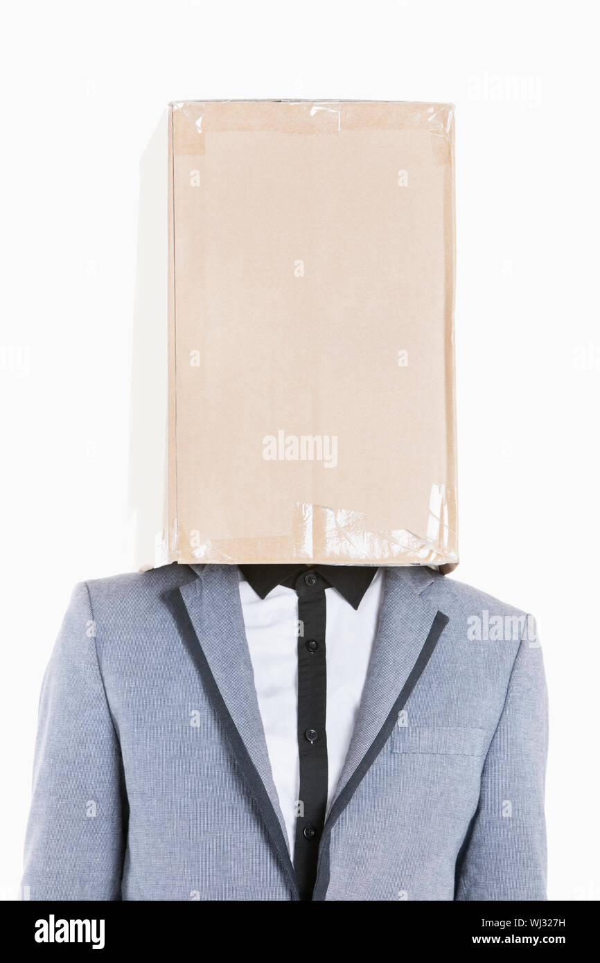 Young boy wearing jacket with box covered over his face on gray ...