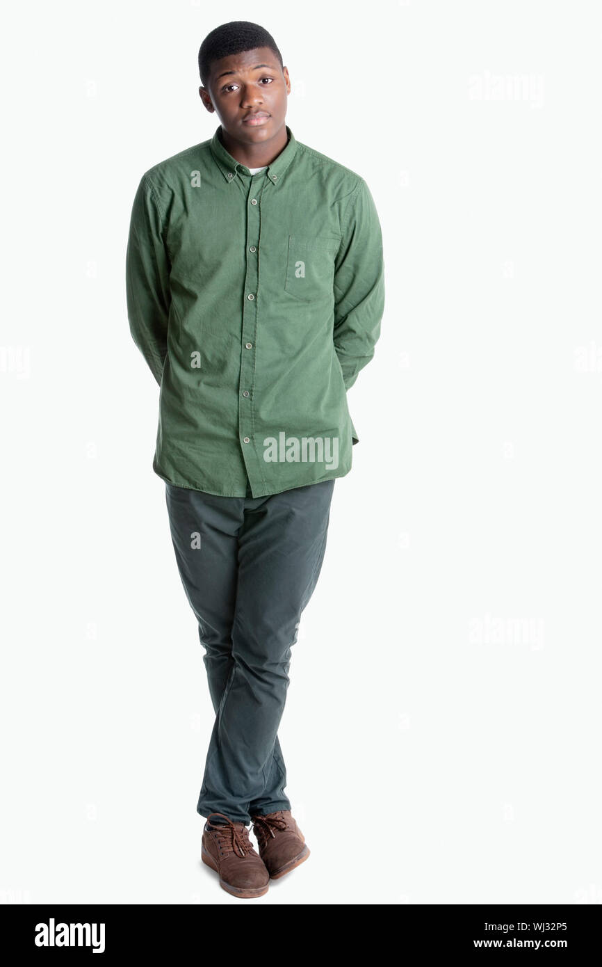 Portrait of a young African American man standing with legs crossed ...