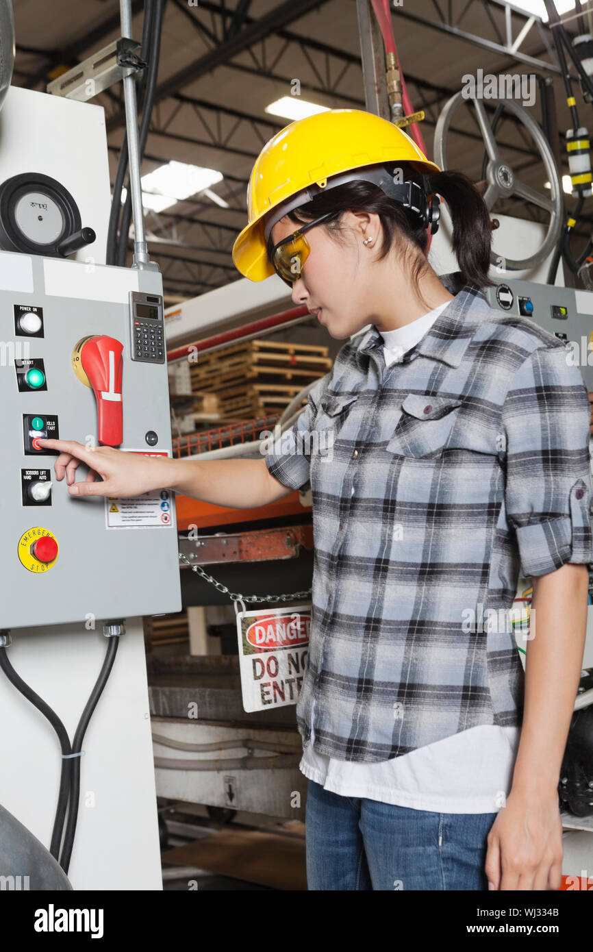 Female industrial worker operating manufacturing machine at factory ...