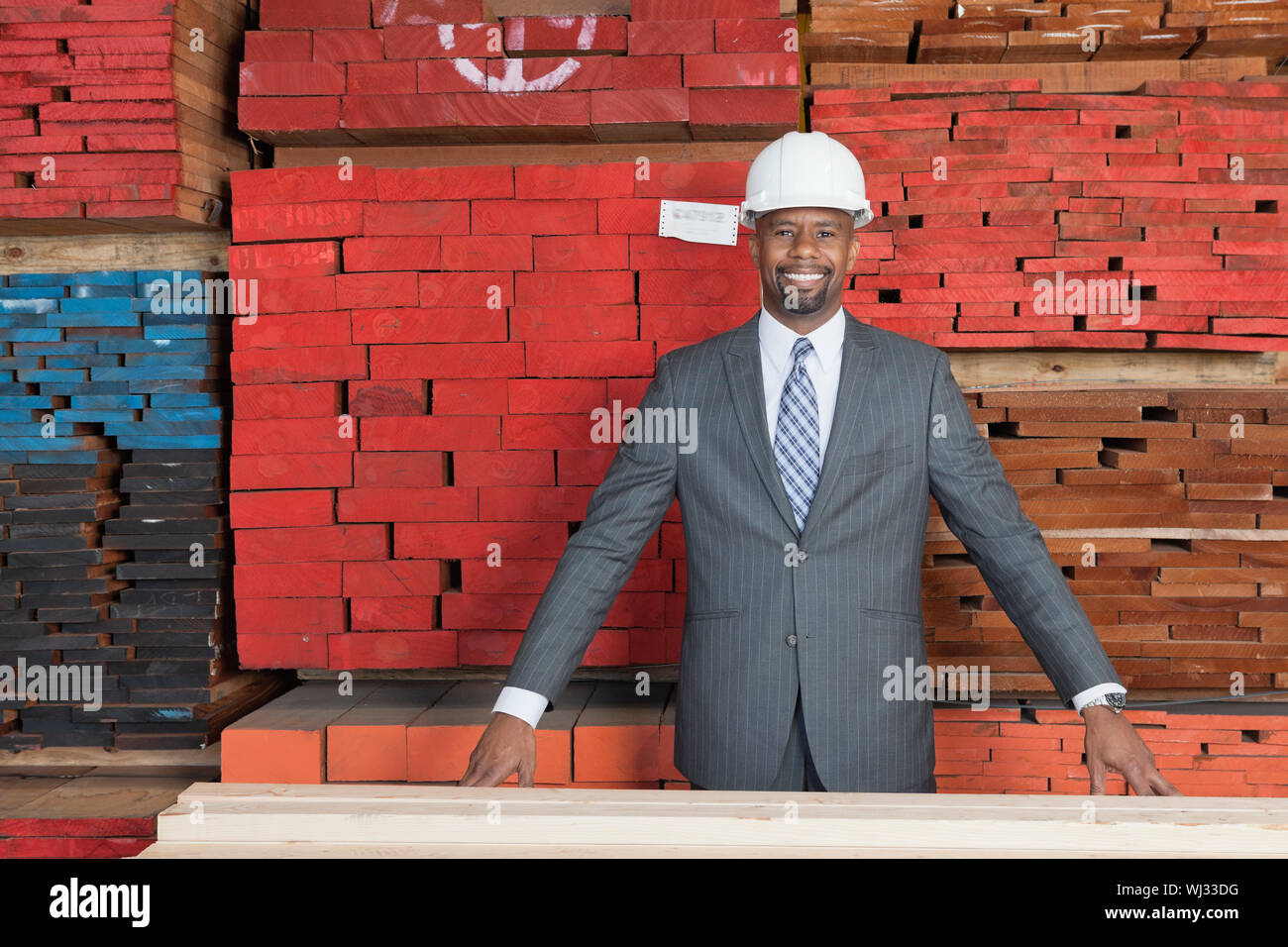 Portrait of happy African American male contractor standing in front of ...