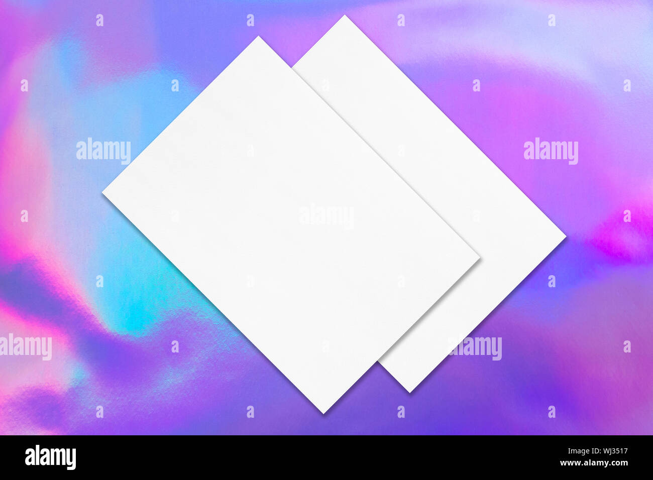 Two empty white rectangle poster mockups lying diagonally on top of ...