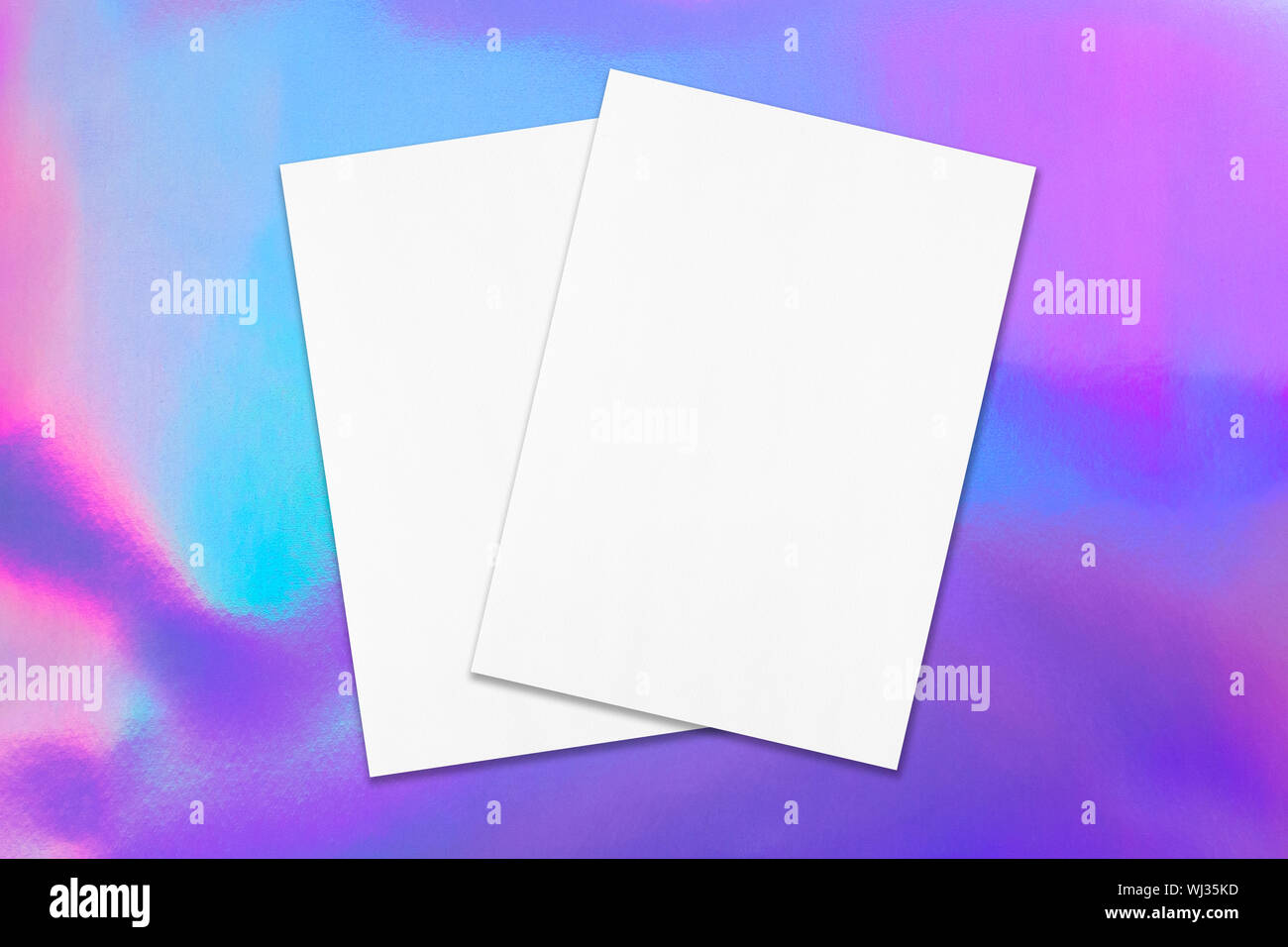 Two empty white rectangle poster mockups lying diagonally on top of ...