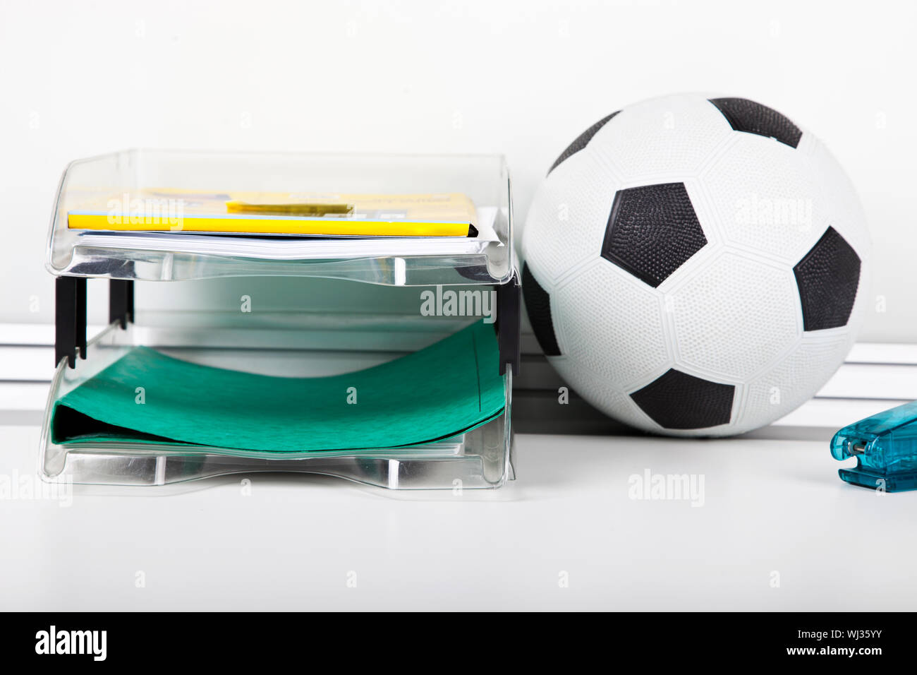 Soccer ball near file rack at desk Stock Photo - Alamy