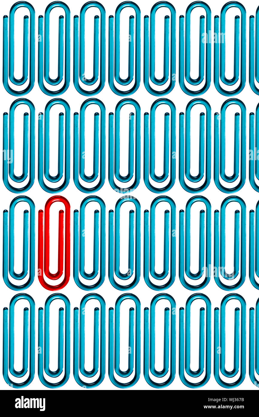 Red paper clip standing out from the crowd of blue paper clips over ...