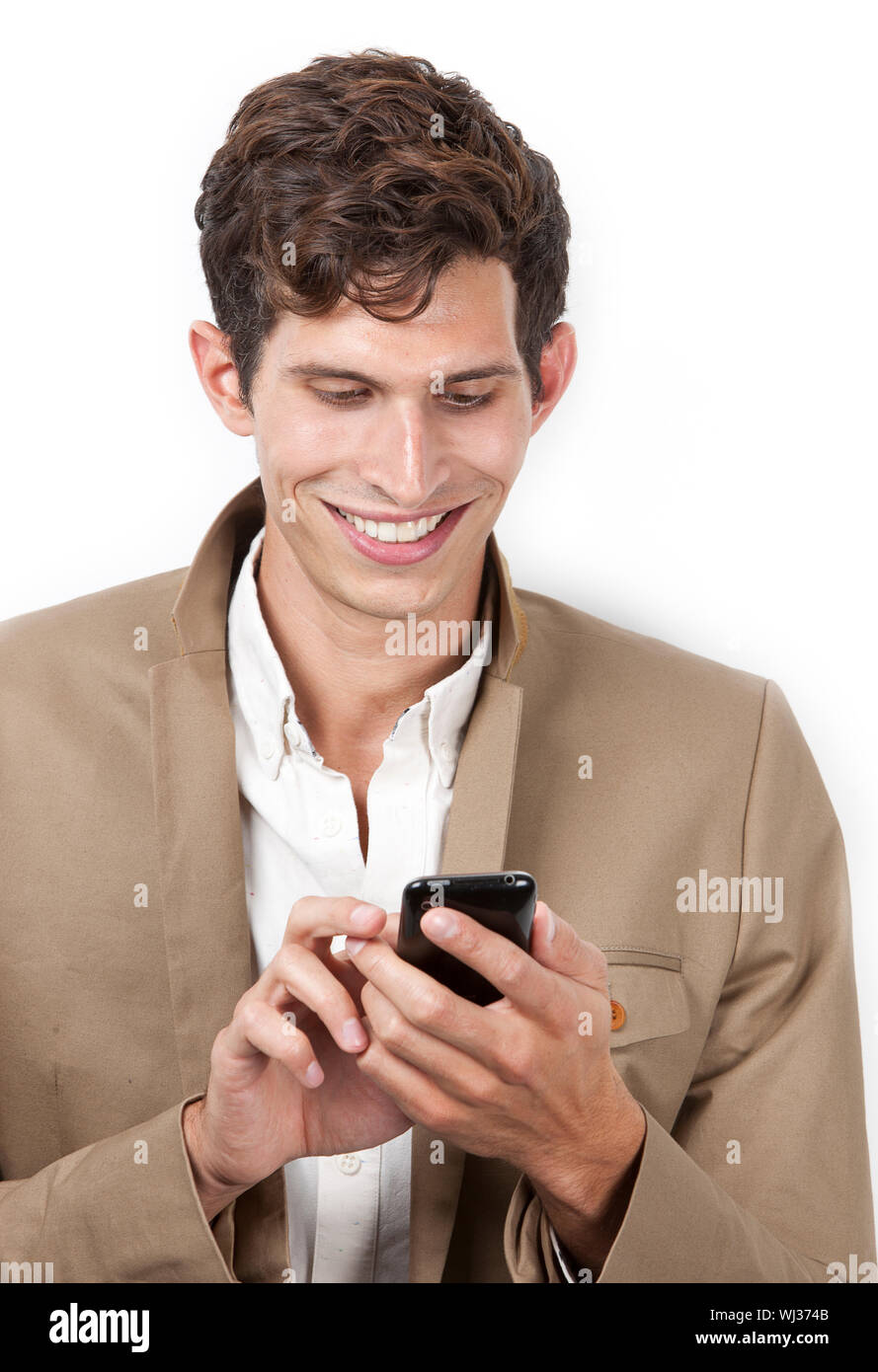 Happy young man text messaging against white background Stock Photo - Alamy