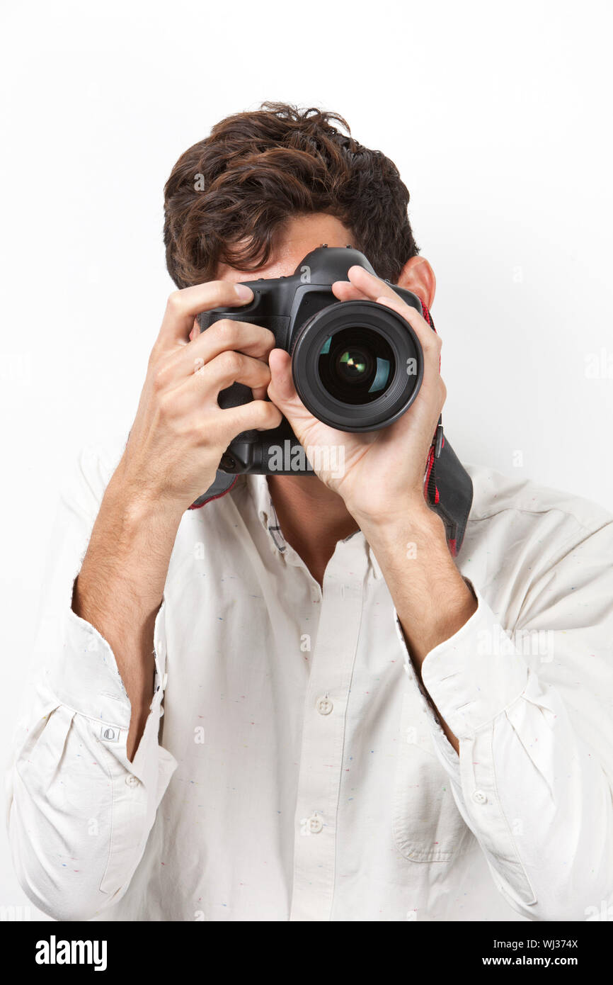 Young man taking photograph with retro style camera against white ...