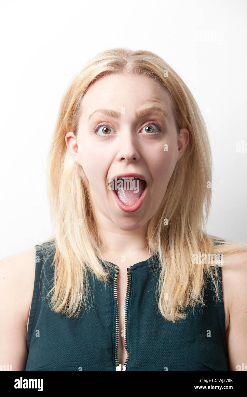 Portrait of shocked young woman screaming against white background ...