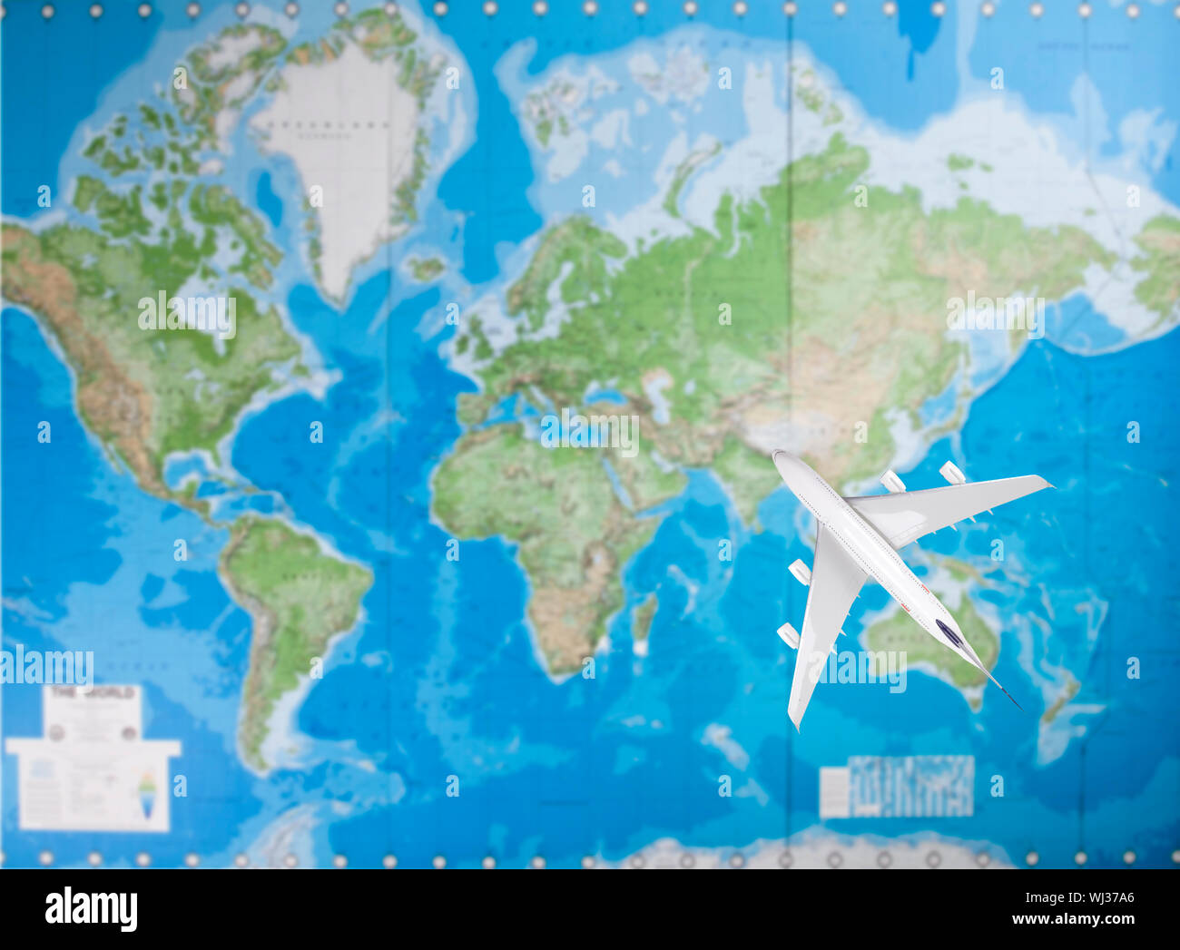 Model airplane flying over world map Stock Photo - Alamy