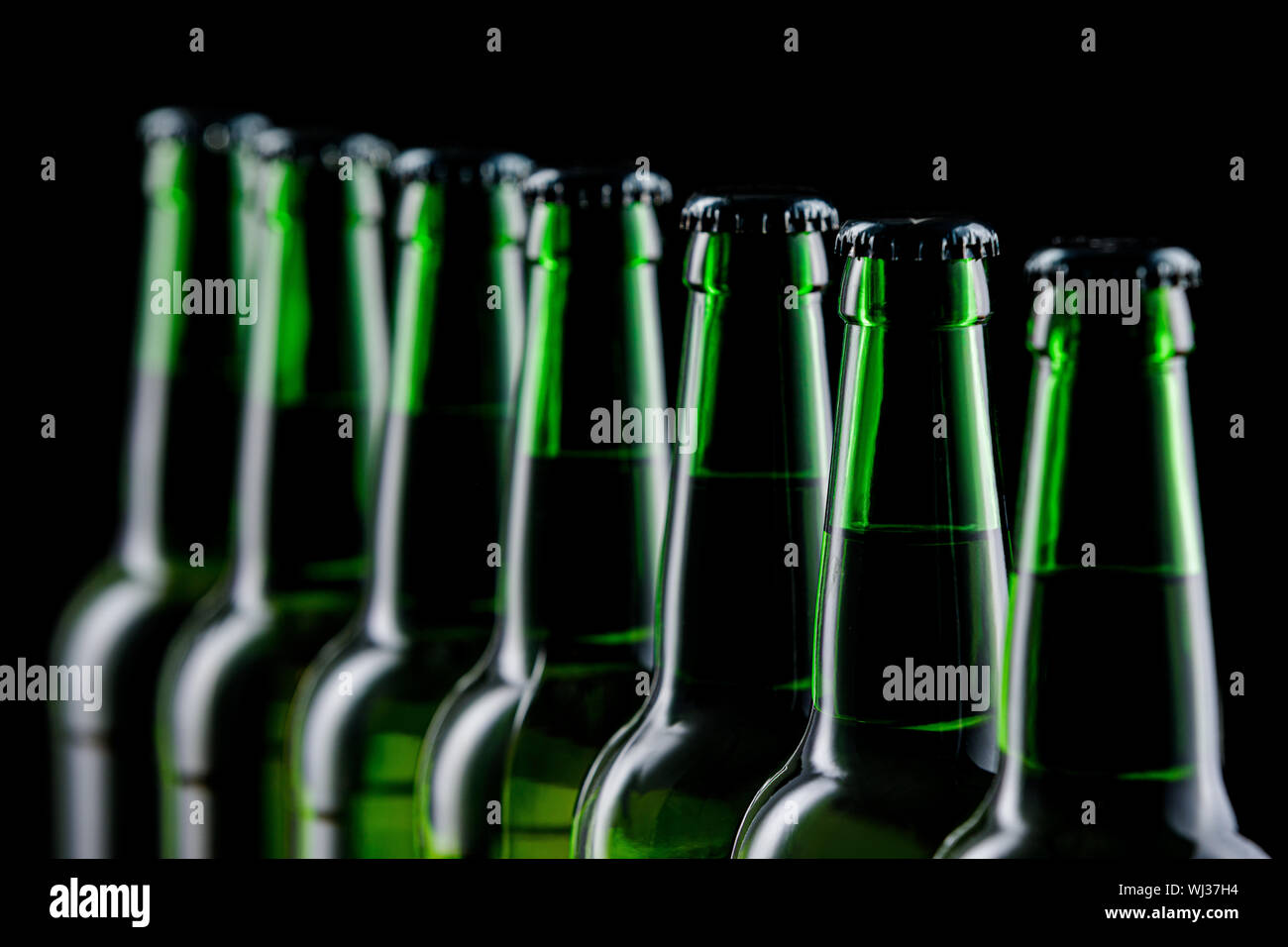 Row of glass bottles of beer on dark background Stock Photo - Alamy