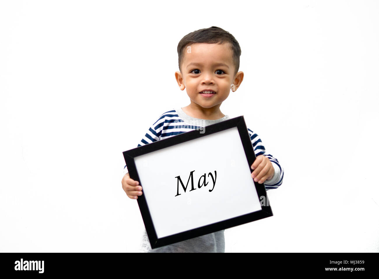 Portrait Of Boy Holding Frame With May Text Against White Background ...