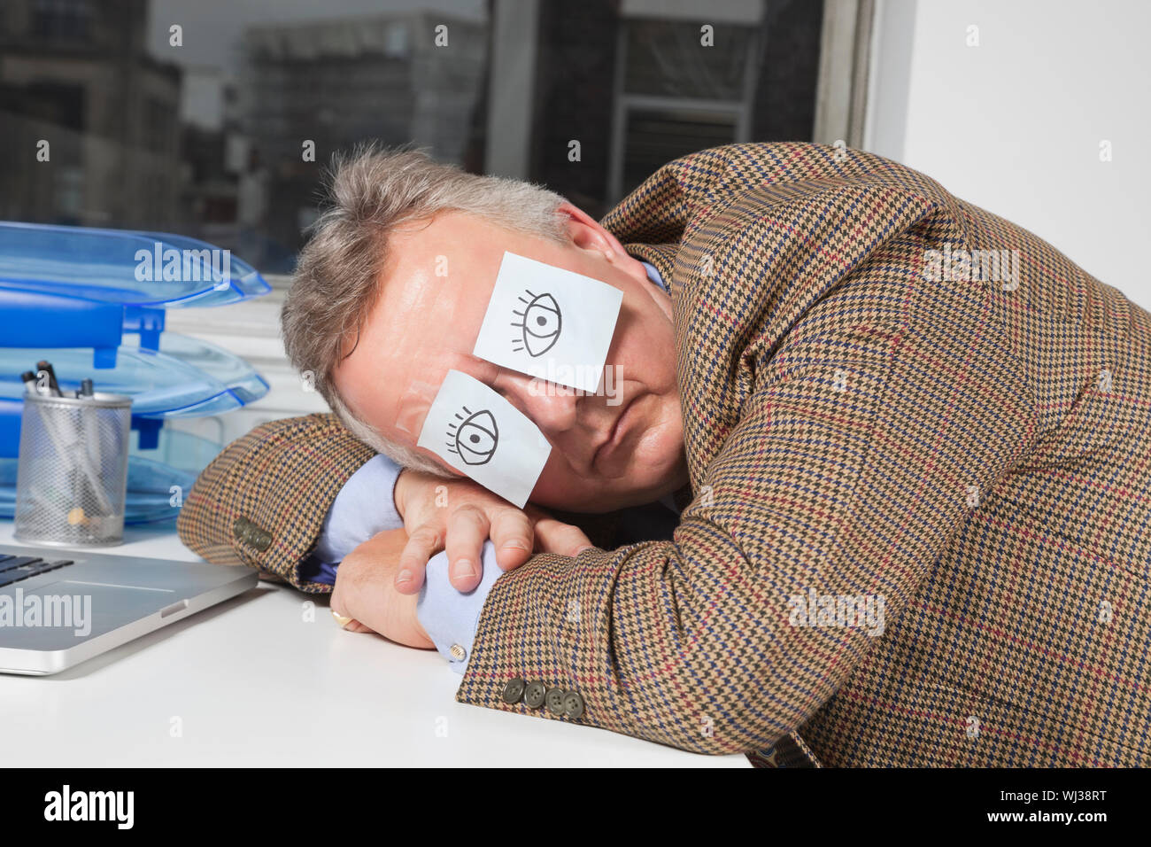 Businessman sleeping with sticky notes on eyes at desk in office Stock ...