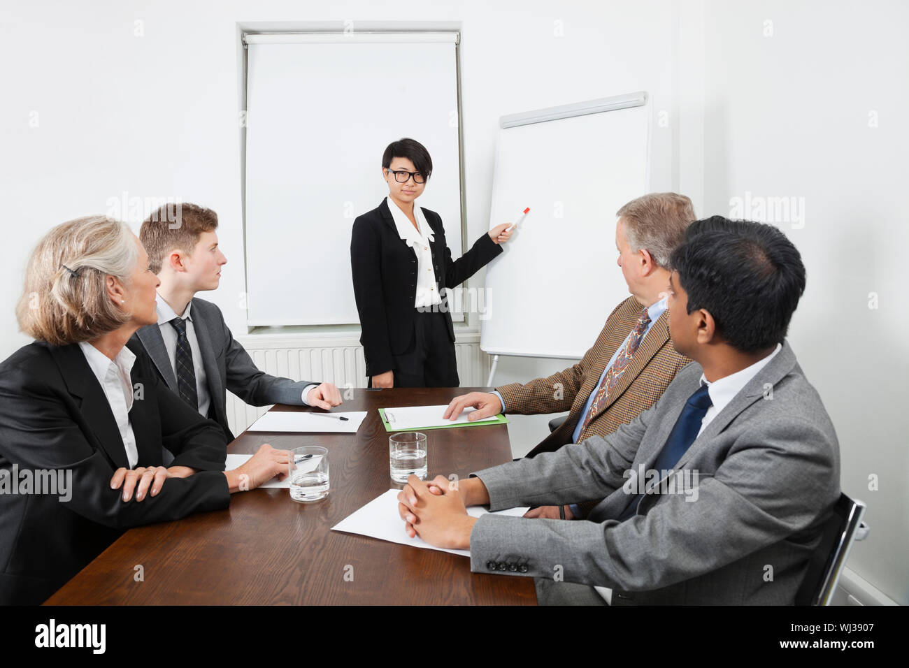 Young woman using whiteboard in business meeting Stock Photo - Alamy