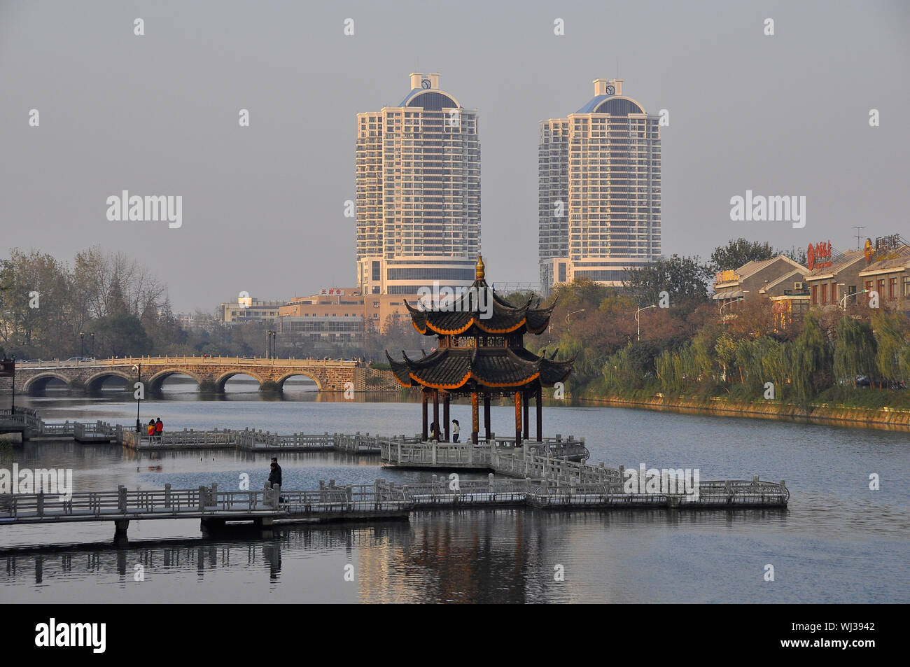 A traditional pagoda stands in front of two modern apartment blocks in ...
