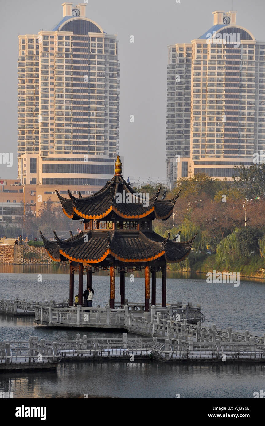 A traditional pagoda stands in front of two modern apartment blocks in ...