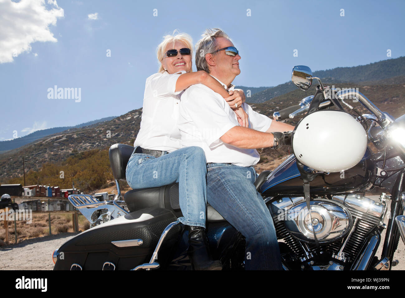 Senior couple riding a motorcycle together in a rural landscape Stock ...