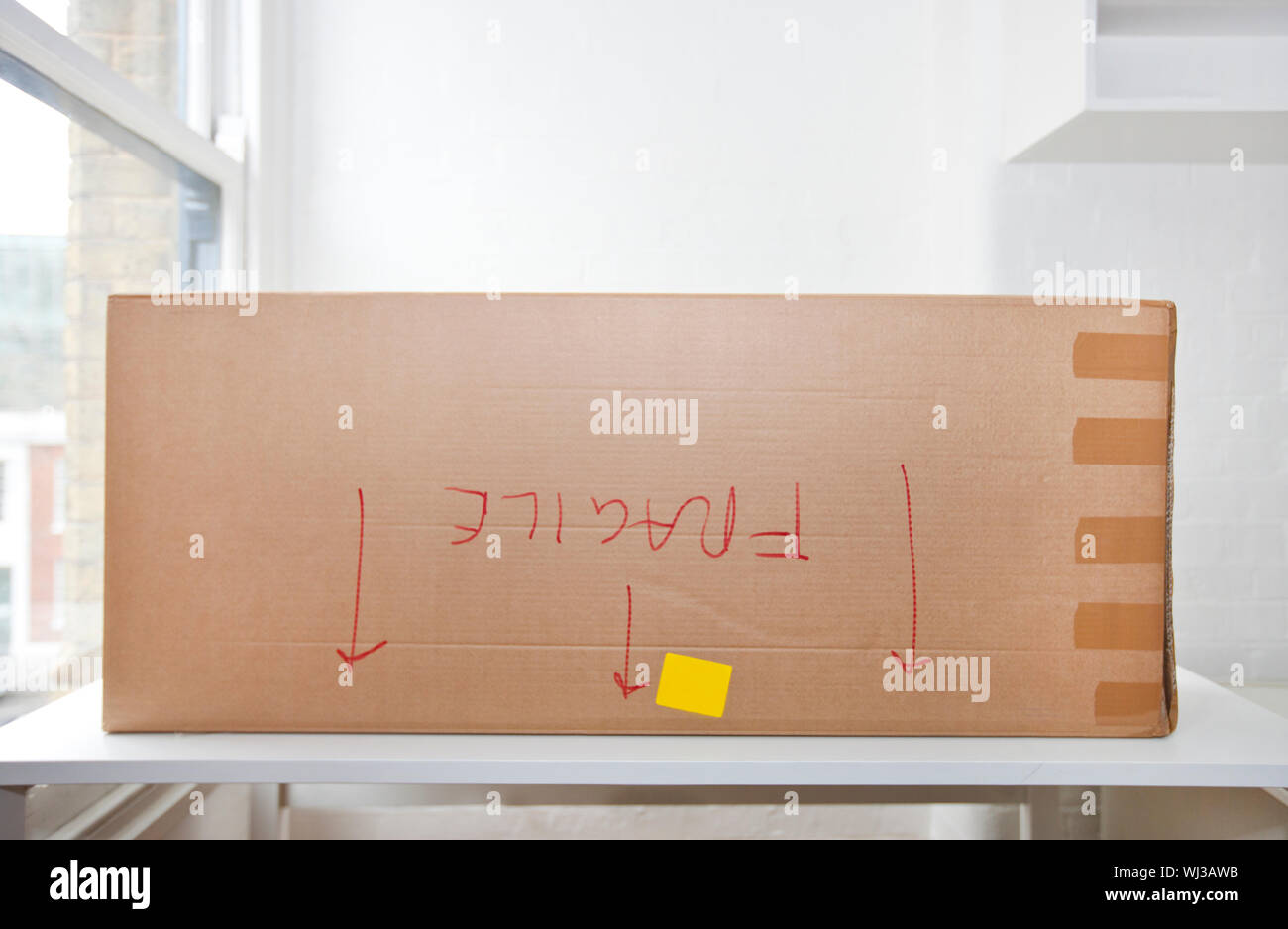 Cardboard box marked "fragile" upside down Stock Photo - Alamy