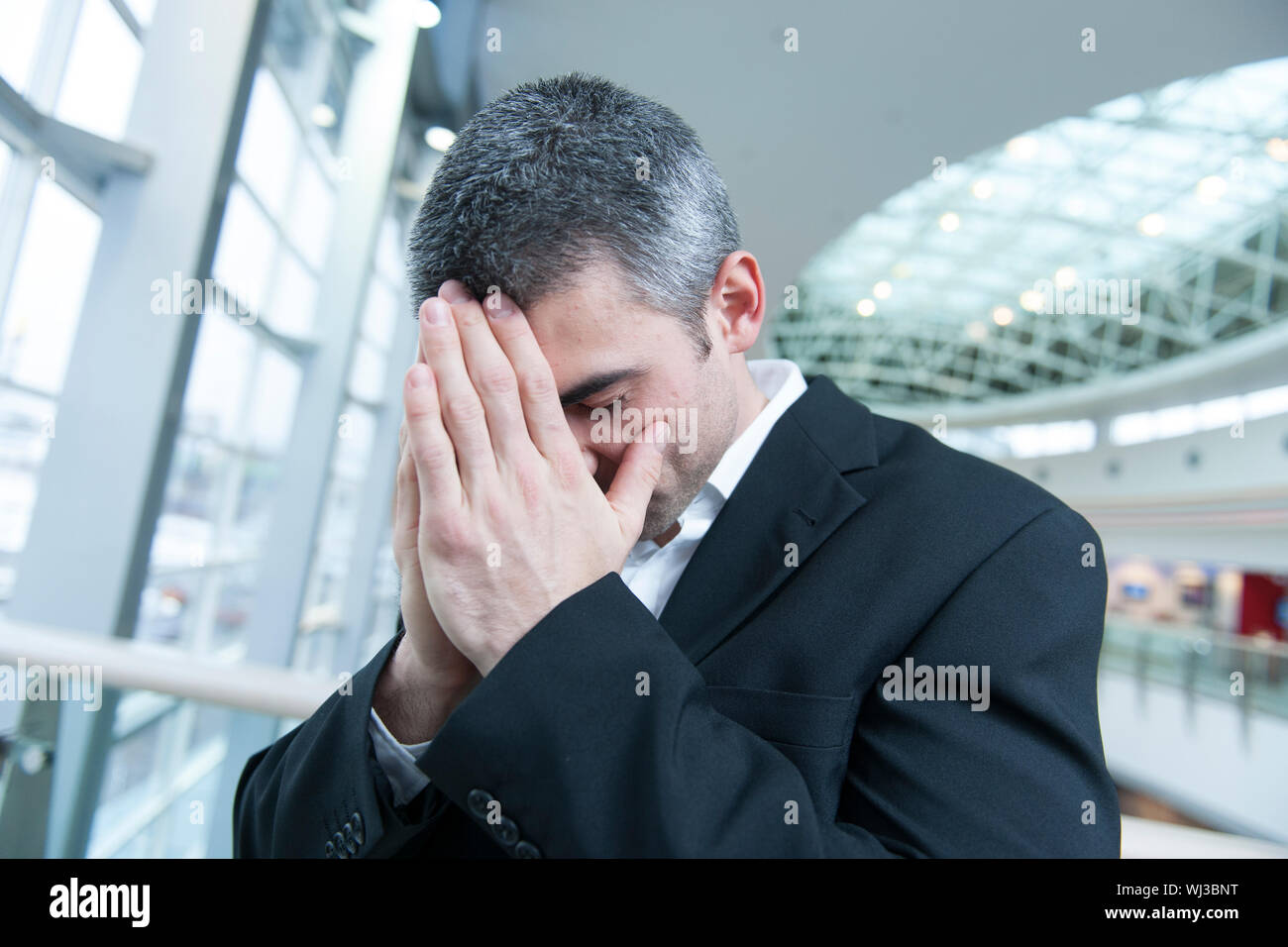 Disappointed businessman with head in hands Stock Photo - Alamy