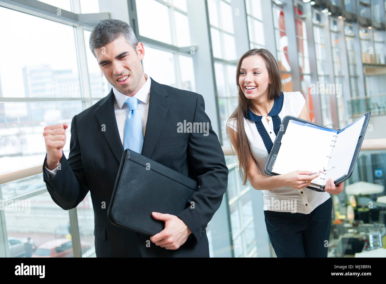 Businessman celebrates good news from coworker Stock Photo - Alamy