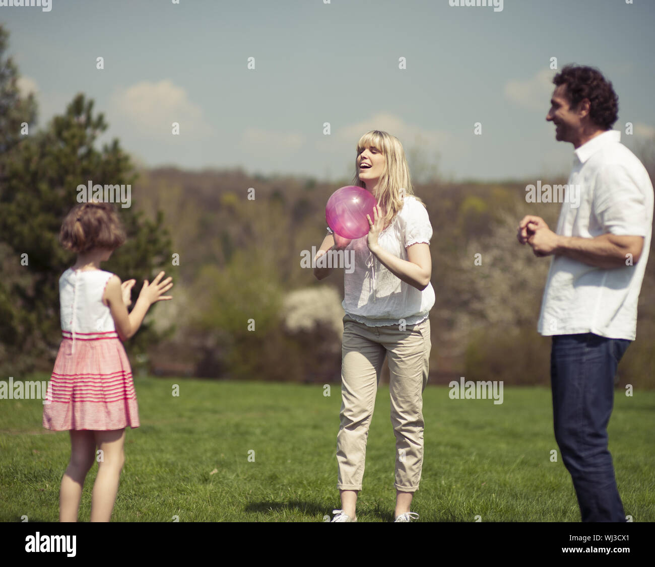 Family throwing ball to each other in the park Stock Photo - Alamy