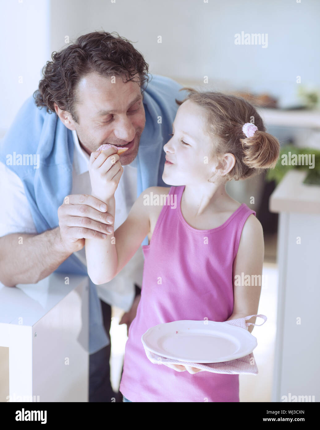 Young girl feeding her father Stock Photo - Alamy