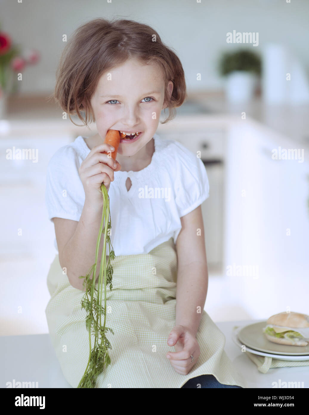 Young girl eating carrot Stock Photo - Alamy