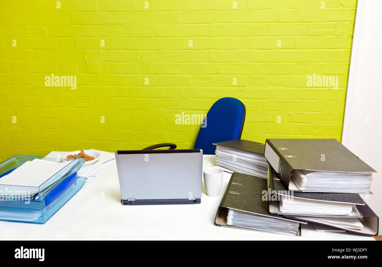 Vacant desk with laptop, folders and empty chair Stock Photo - Alamy