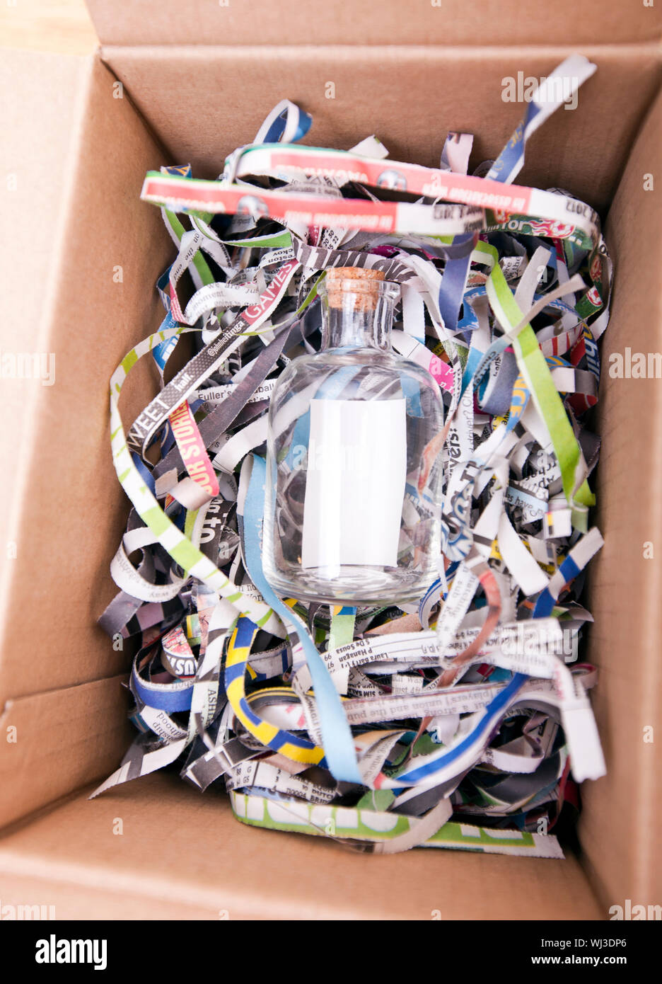 Glass bottle wrapped in a box Stock Photo - Alamy