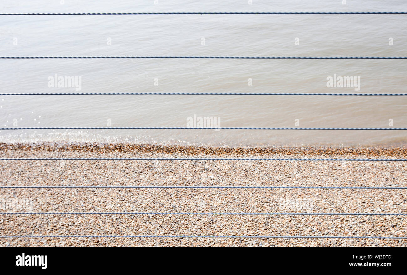 River Thames and Shingle beach behind wire rope fence Stock Photo - Alamy