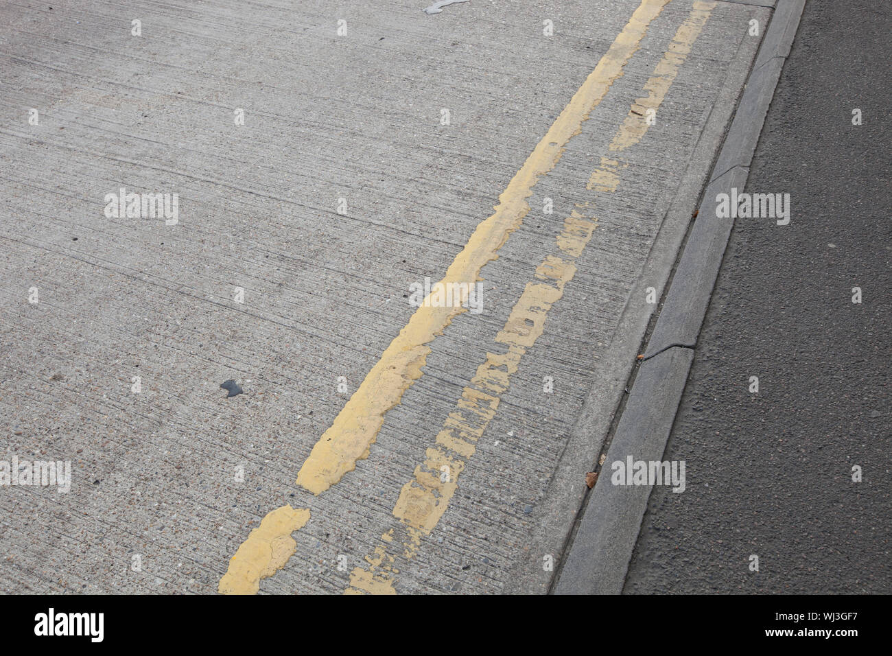 Close-Up of double yellow line on road Stock Photo - Alamy