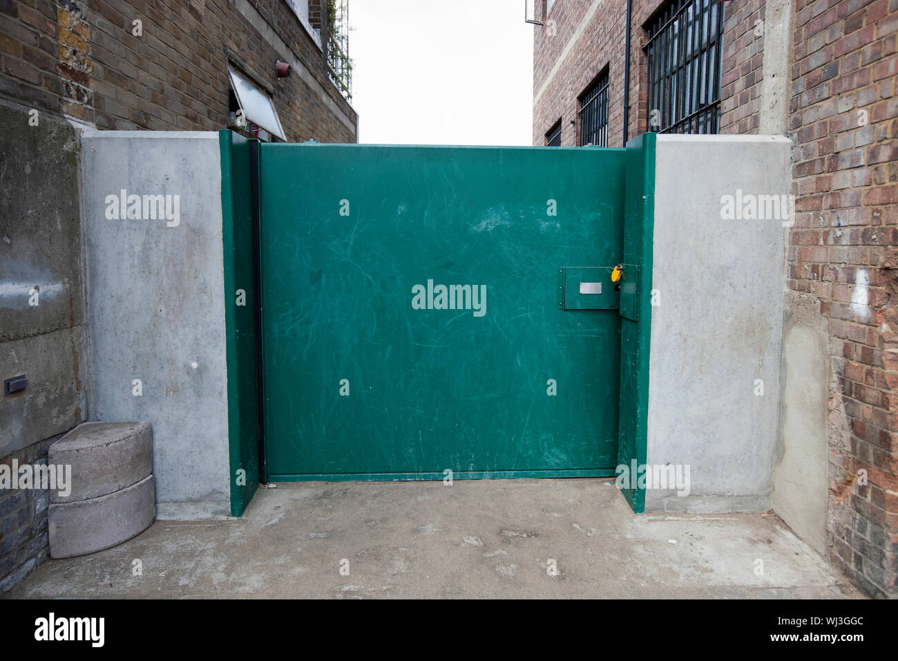 Closed green gate connected to buildings Stock Photo - Alamy