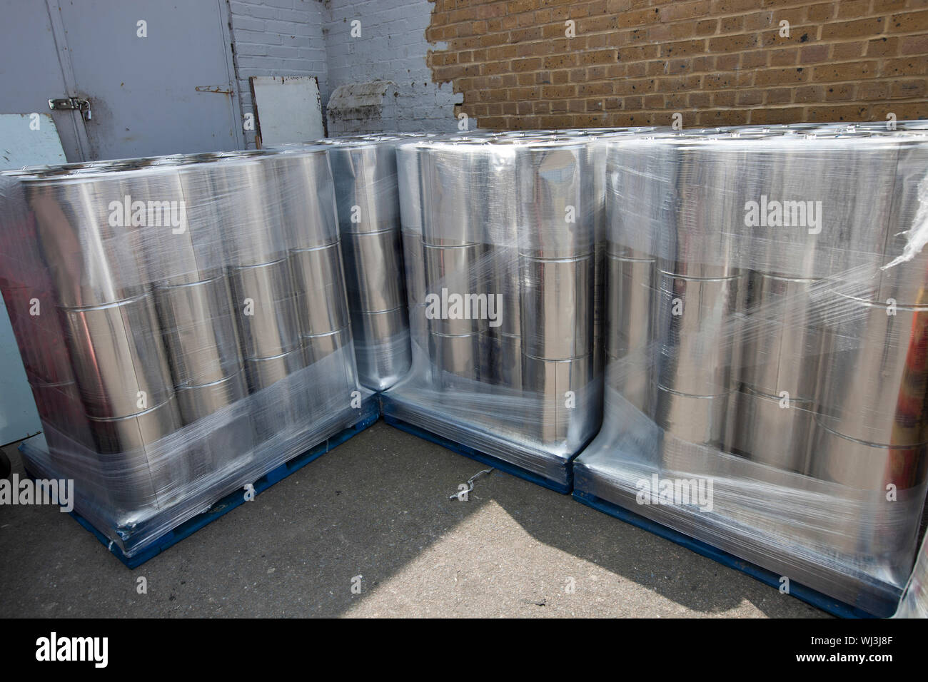 Stack of tins outside warehouse Stock Photo - Alamy