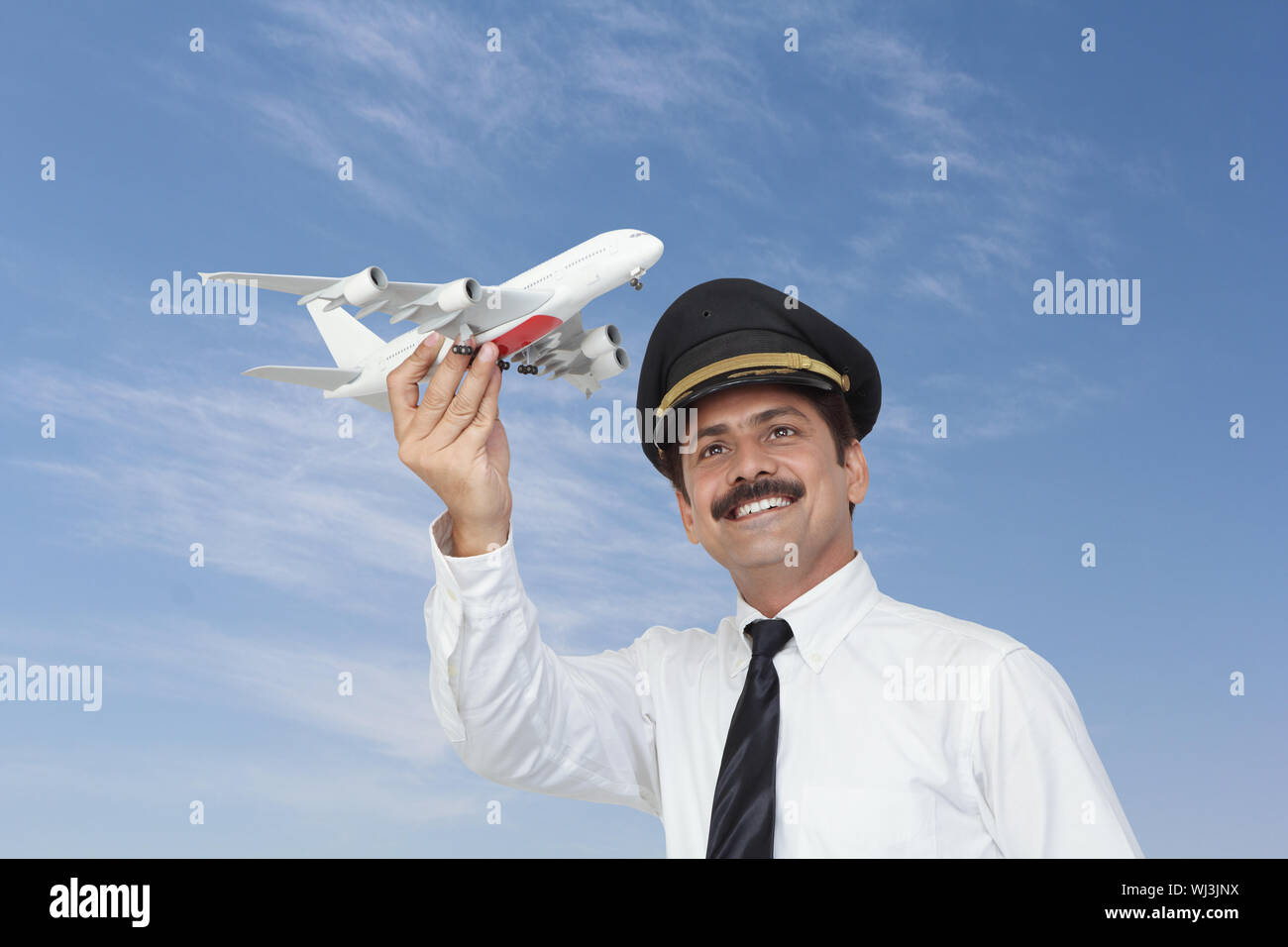 Pilot flying model airplane and smiling Stock Photo - Alamy