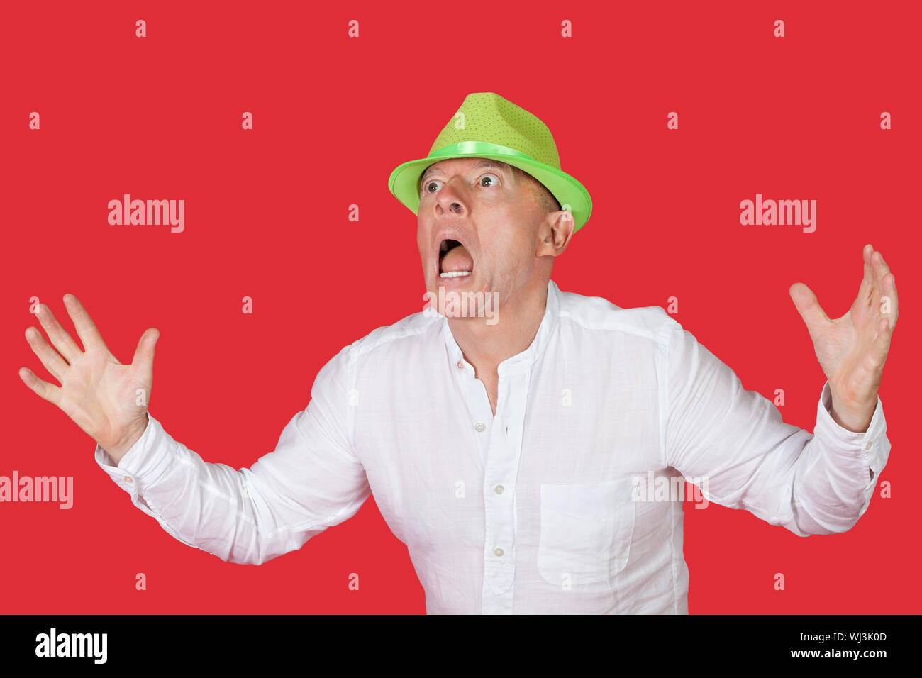 Portrait of an shocked man screaming against red background Stock Photo ...