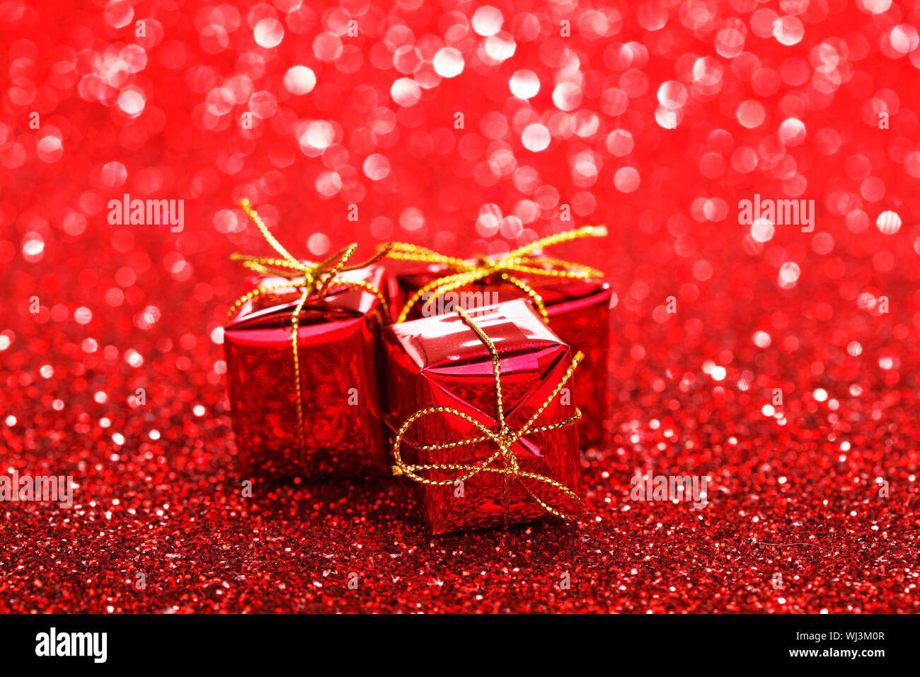 Red Christmas gift boxes on shiny glitter background Stock Photo - Alamy
