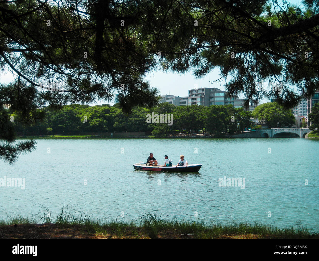 people riding small boat in large body of water in fukuoka japan ...