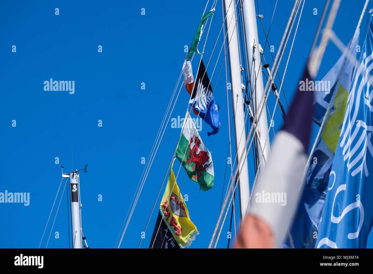 collection of flags on a sail boat with a beautiful blue sky backdrop ...