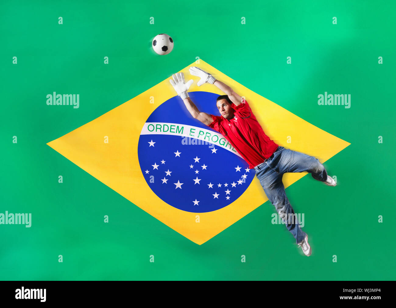 Goalkeeper saving ball in front of Brazilian flag Stock Photo - Alamy