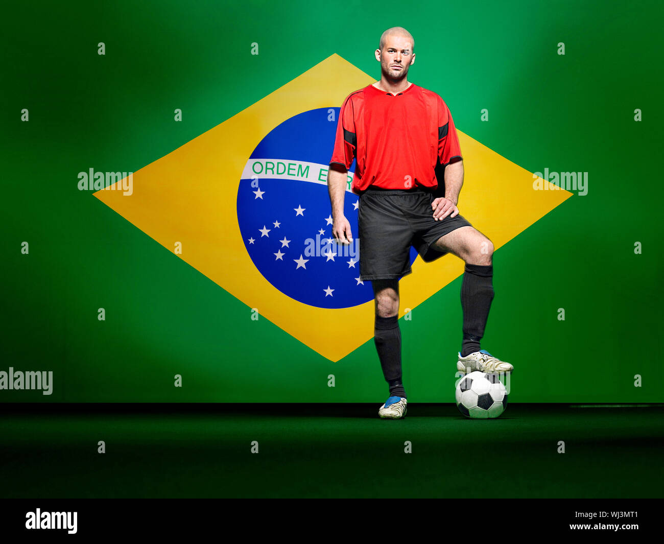 Soccer player standing in front of Brazilian flag Stock Photo - Alamy