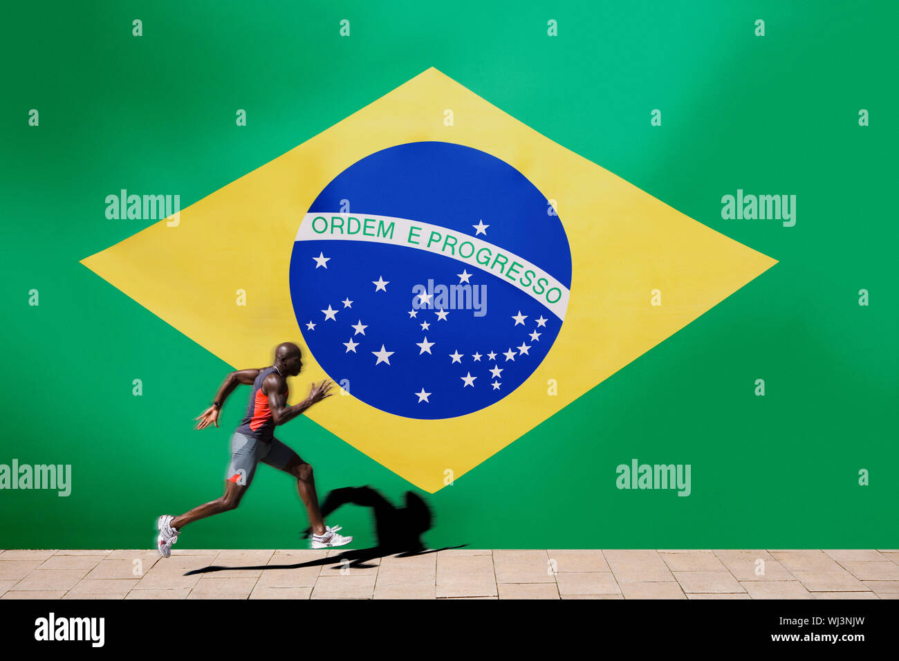 Athlete running past Brazilian flag Stock Photo - Alamy