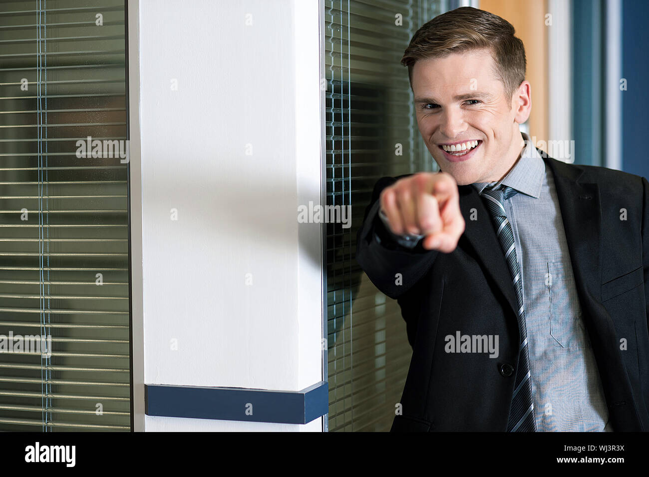 Cheerful corporate guy pointing at camera Stock Photo - Alamy
