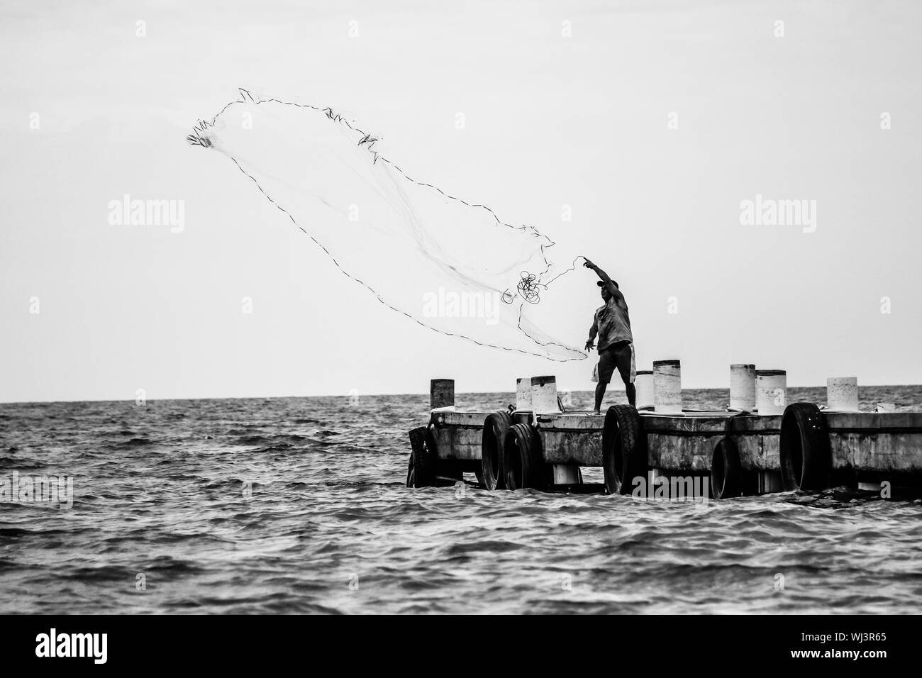 Man Throwing Fishing Net Into Water Stock Photos & Man Throwing Fishing ...
