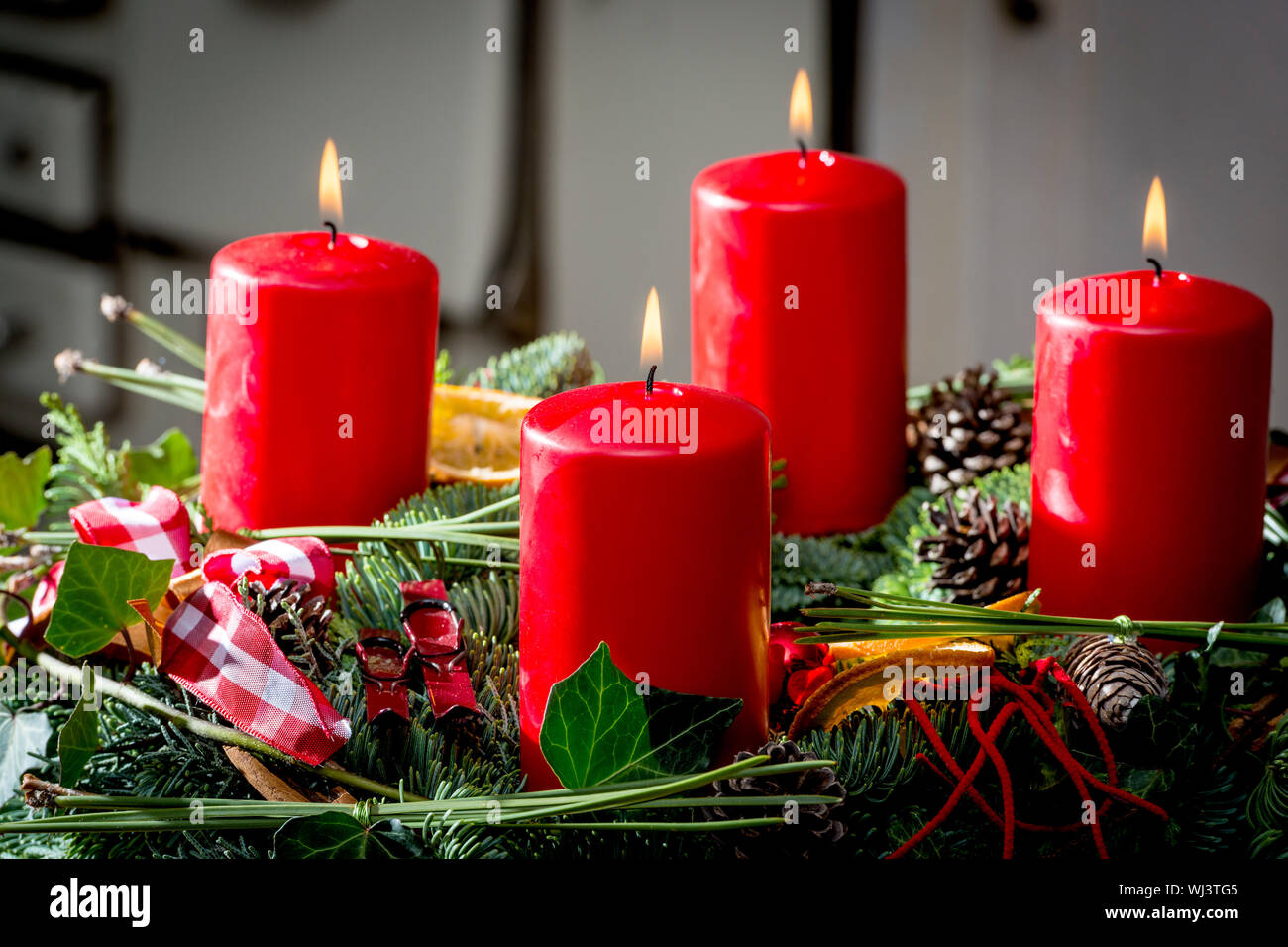 Advent wreath of twigs with four burning red candles and various ...
