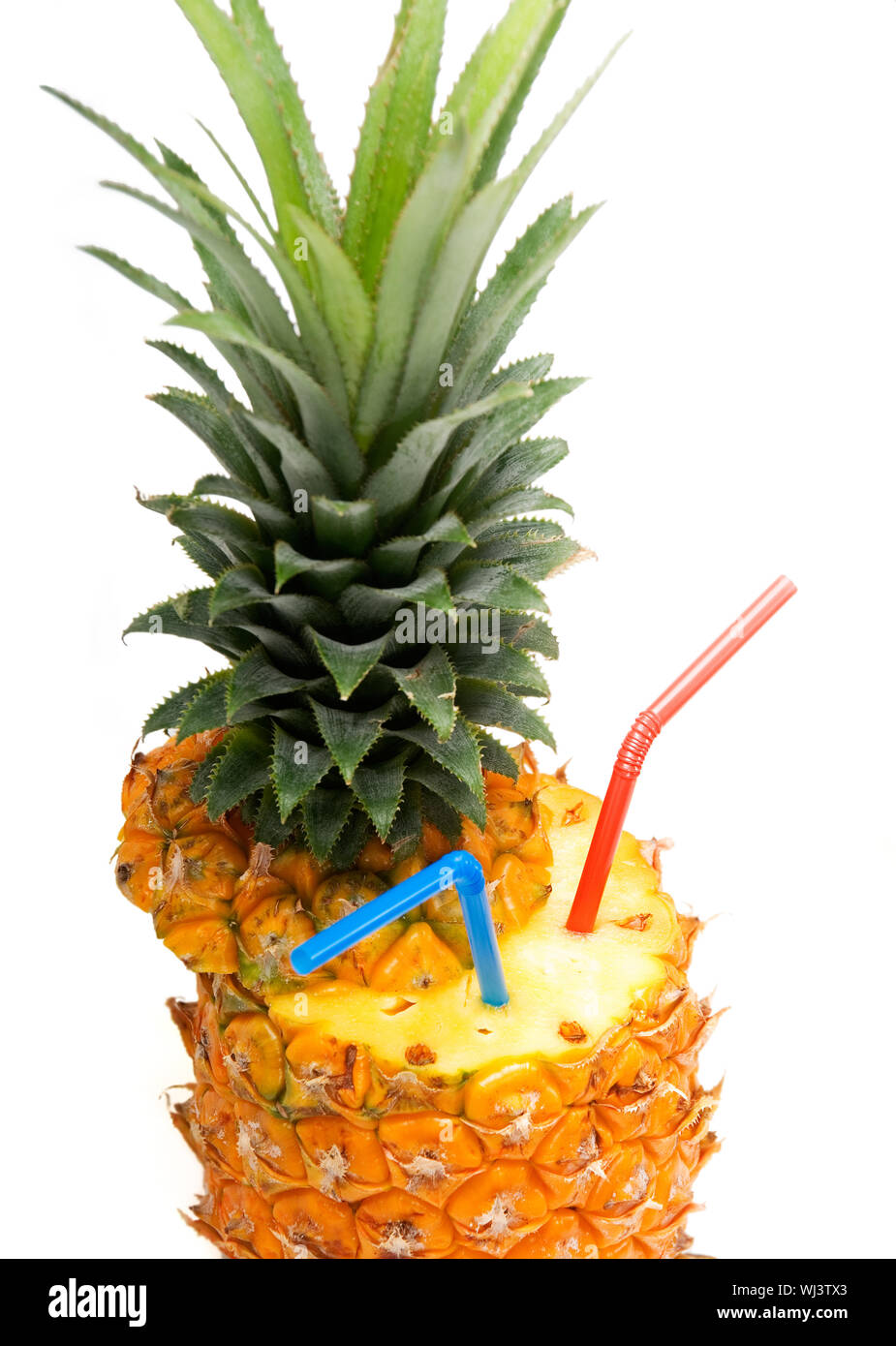 ripe pineapple cutted on top with red and blue straws isolated on white ...