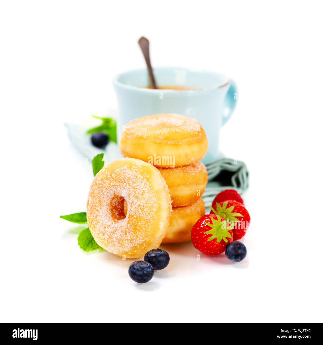 Coffee break with fresh berries and sugary donuts over white background ...