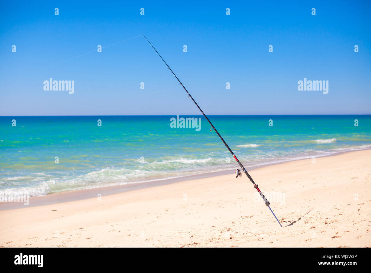 Fishing rod in the sand on the beach in Portugal Stock Photo - Alamy