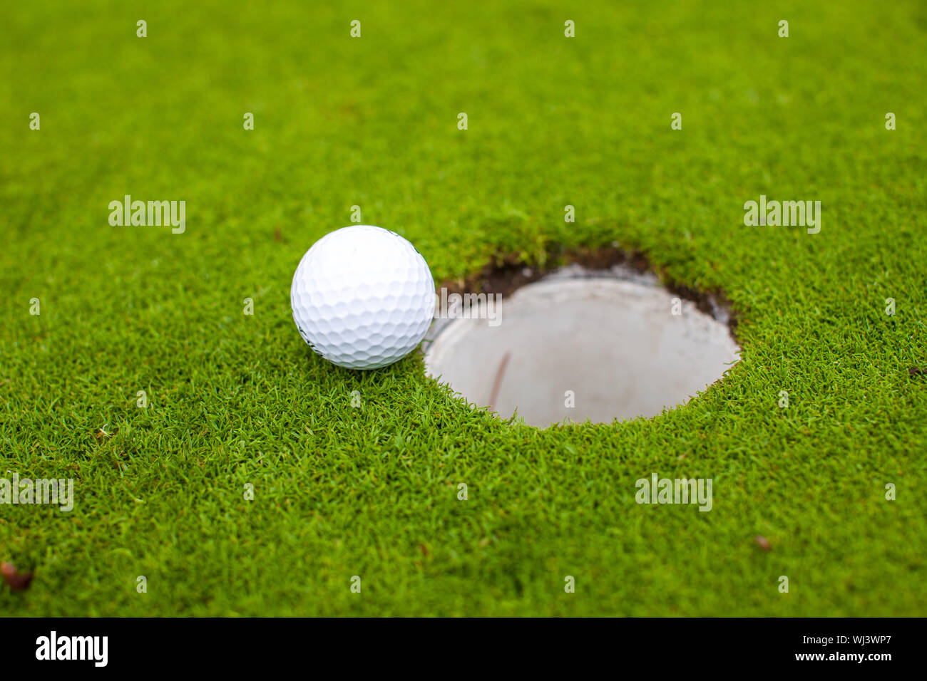 Golf ball go to the hole Stock Photo - Alamy
