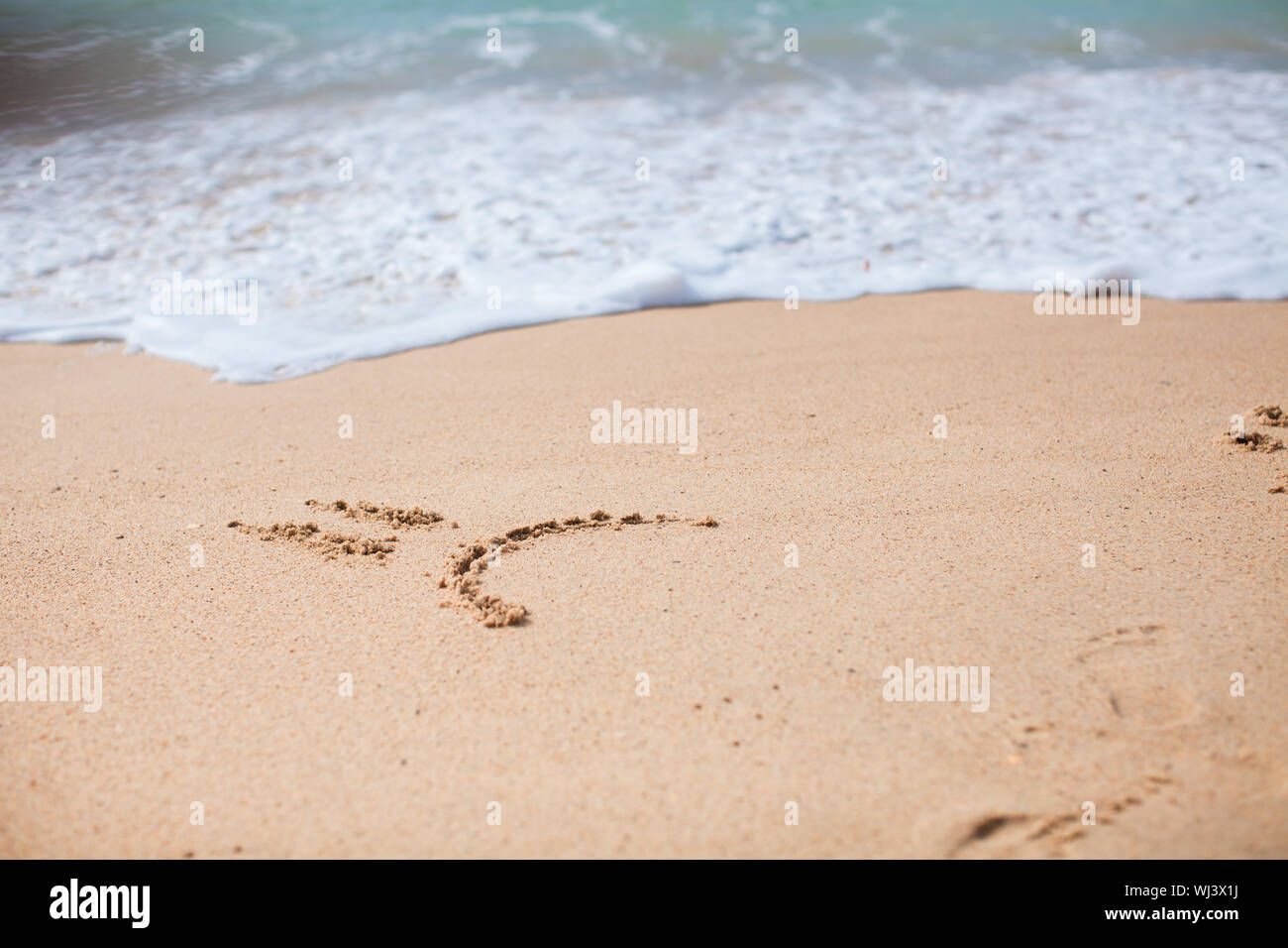 Sad smile drawing on the sand at tropical beach Stock Photo - Alamy