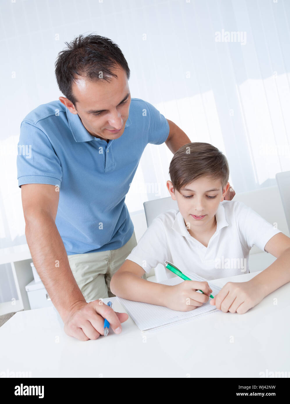 Teacher helping boy exercise hi-res stock photography and images - Alamy