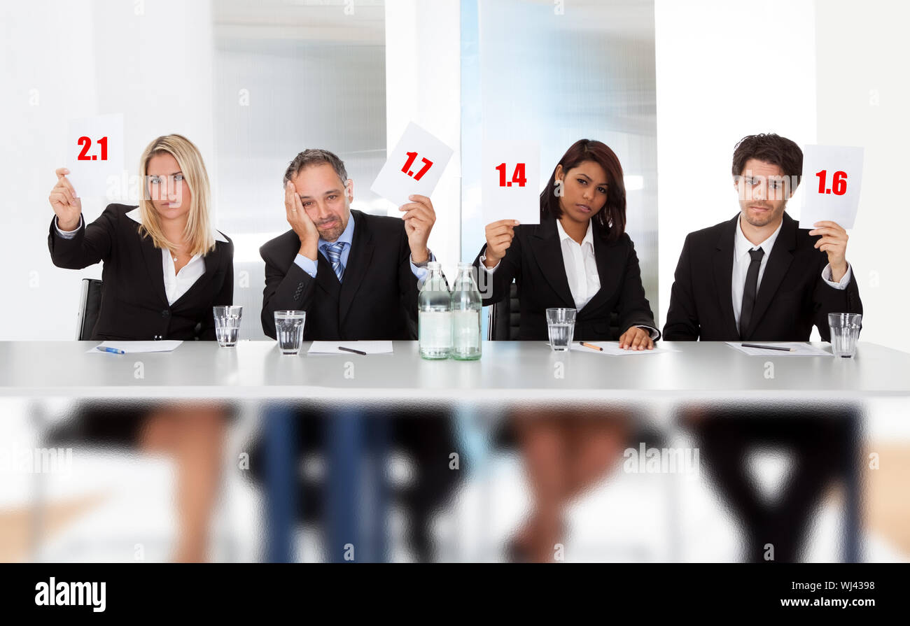 Group of panel judges holding bad score signs Stock Photo - Alamy