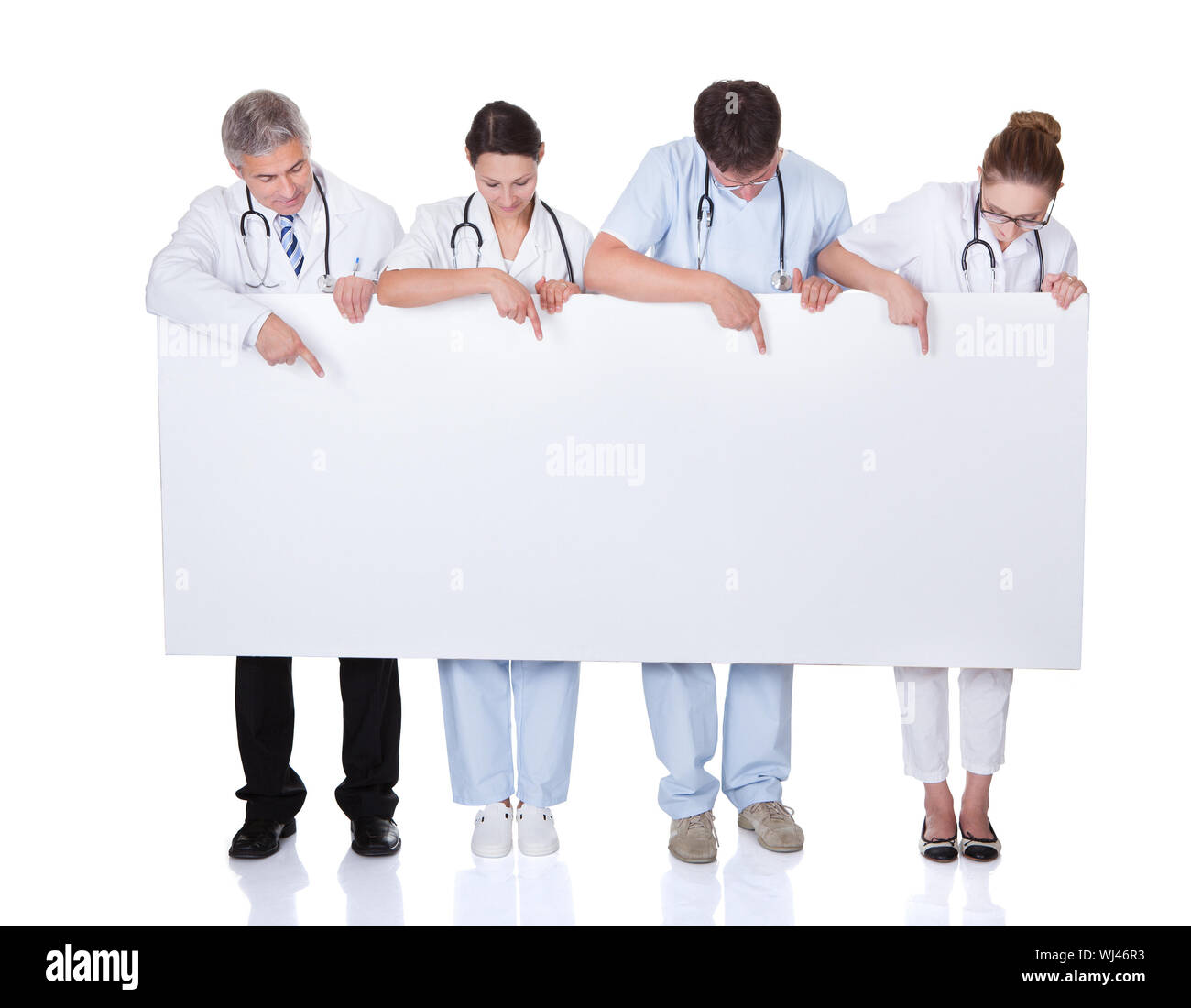 Four attractive professional diverse medical staff holding up a long ...